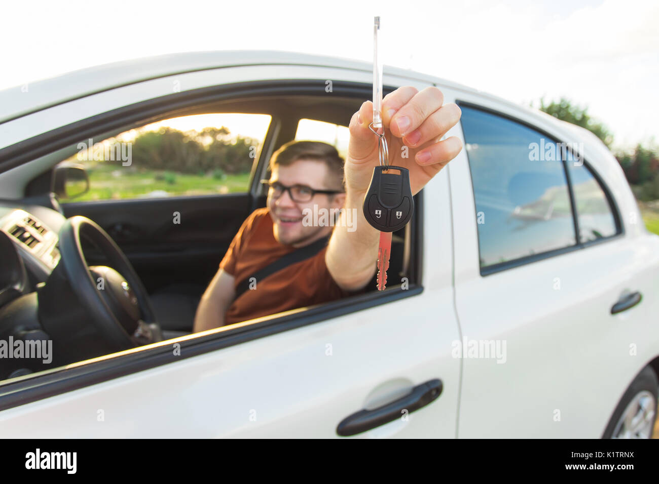 Happy young smiling man sitting inside new car with keys Stock Photo ...