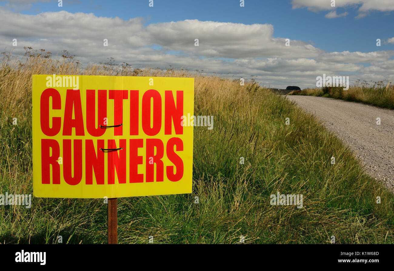 Sign warning about runners on a rural track Stock Photo - Alamy