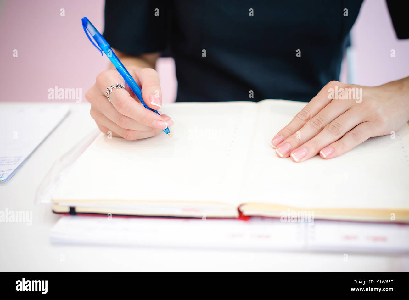 Business woman making notes in notepad. Beautiful well-groomed hands ...