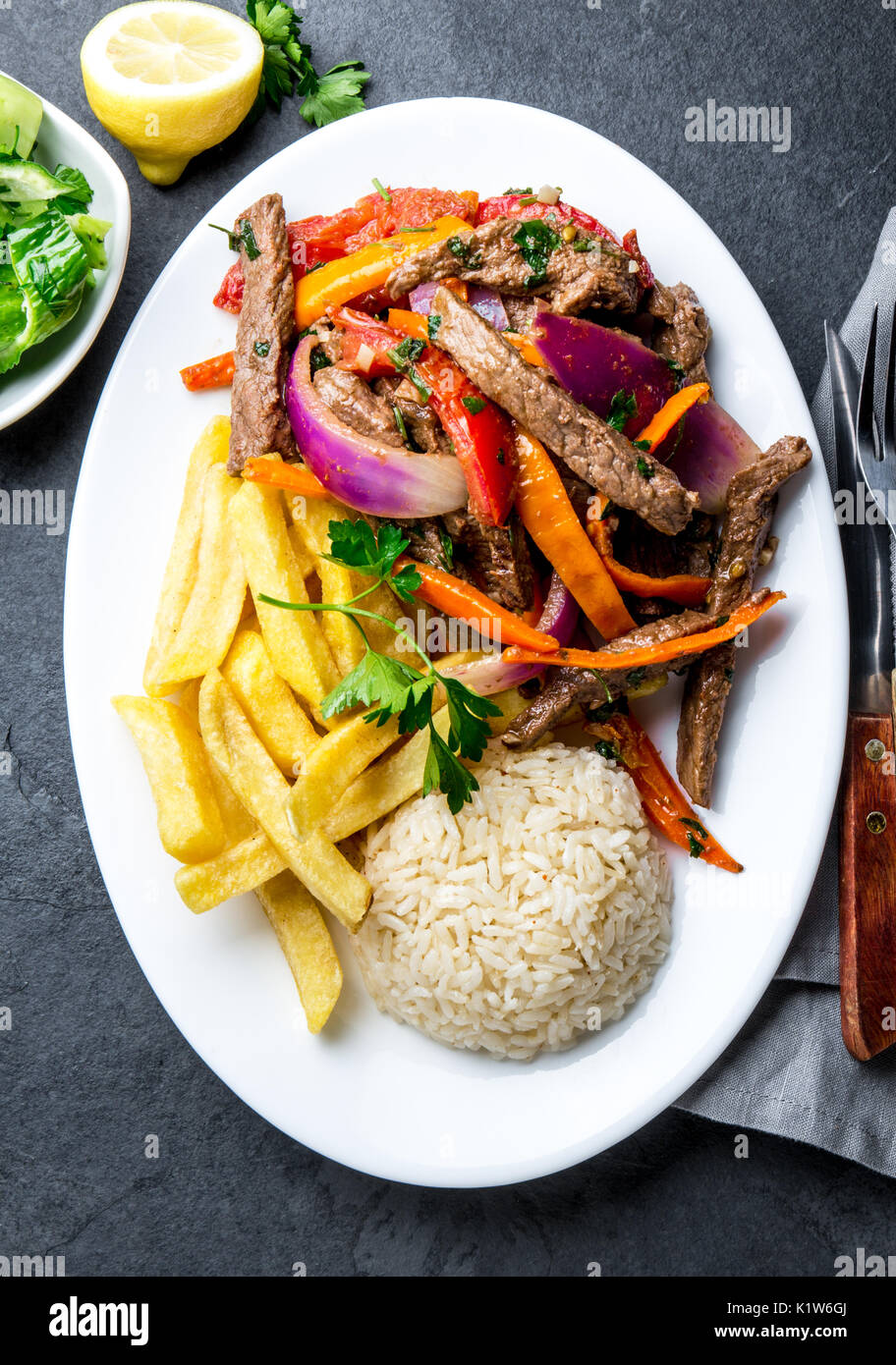 Peruvian dish Lomo saltado - beef tenderloin with purple onion, yellow ...