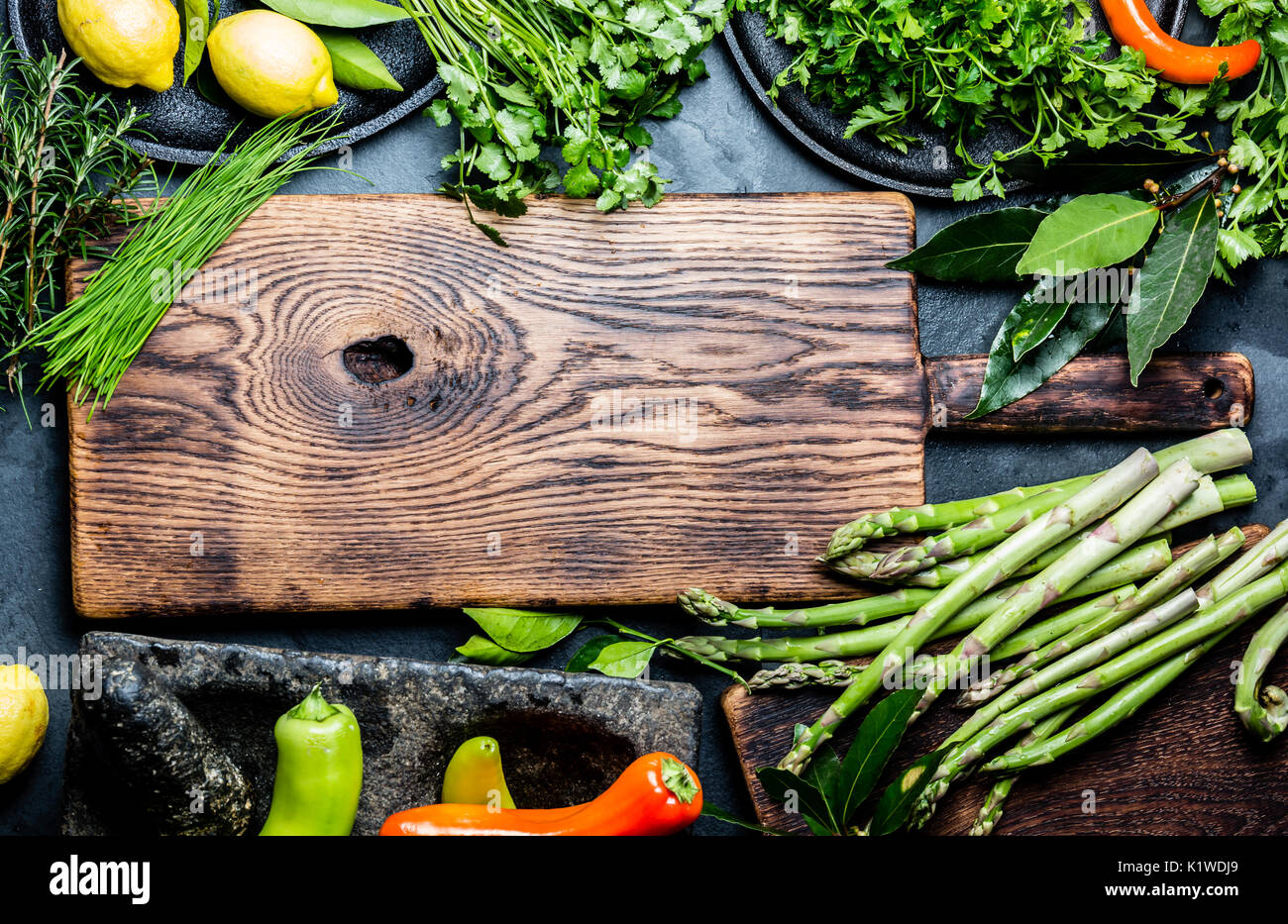 Herbs and spices around wooden cutting board. Top view with copy space ...