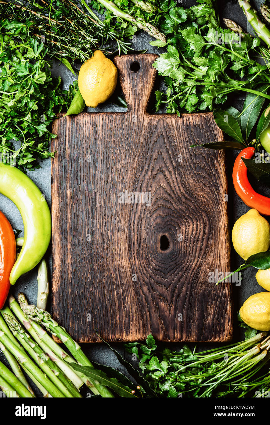 Herbs and spices around wooden cutting board. Top view with copy space ...