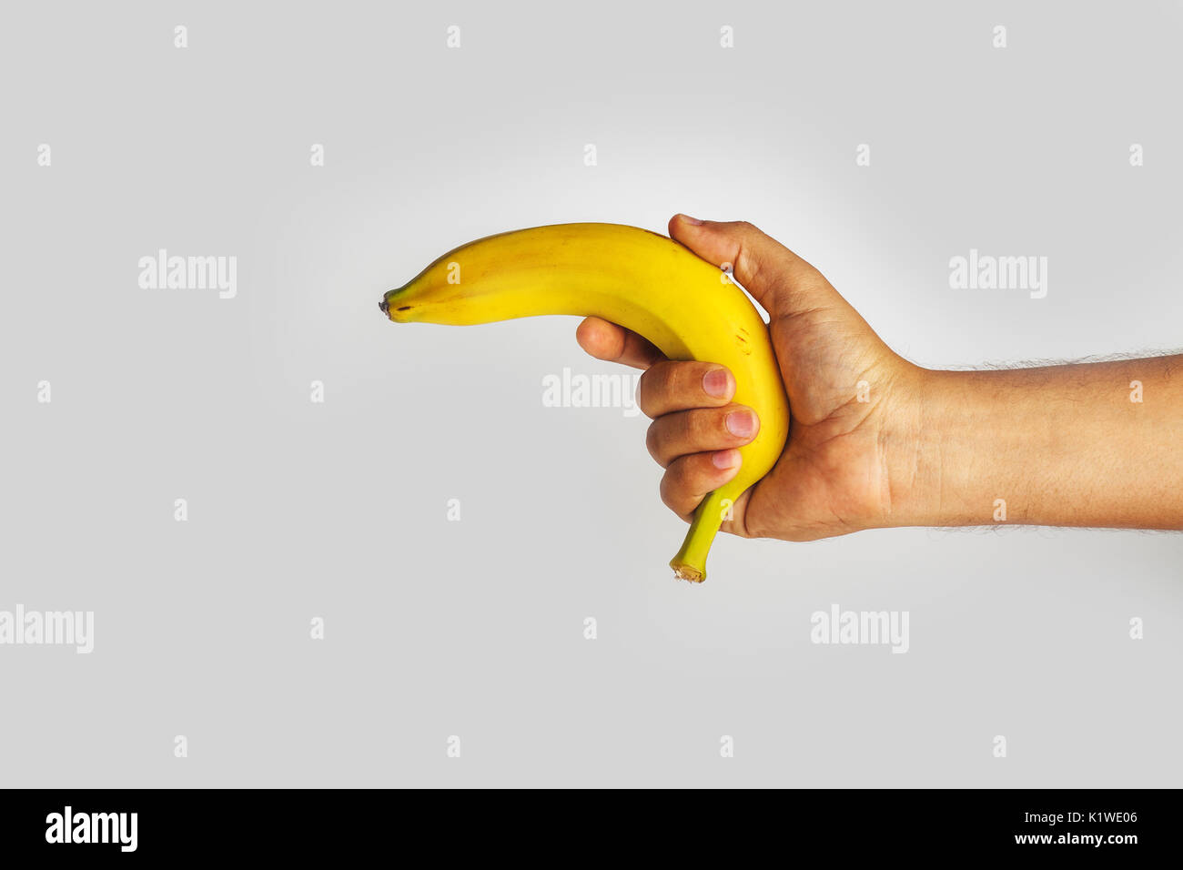 hand holding a banana on a white background Stock Photo - Alamy