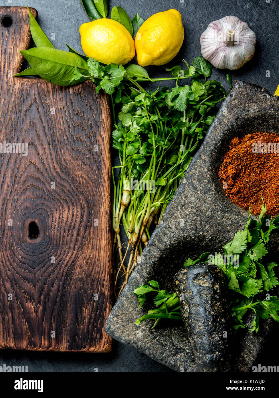 Herbs and spices around wooden cutting board. Top view with copy space ...