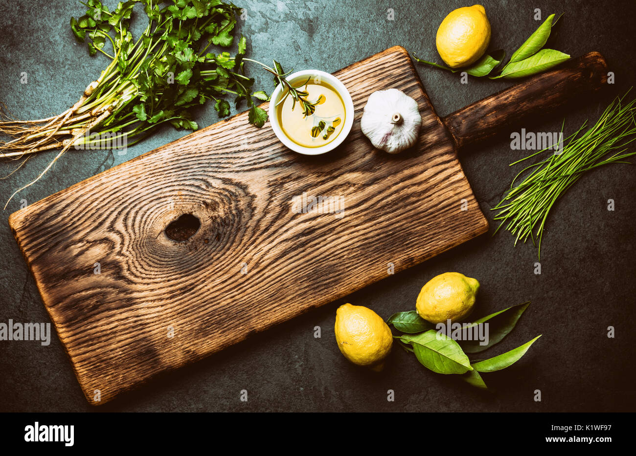 Herbs and spices around wooden cutting board. Top view with copy space ...