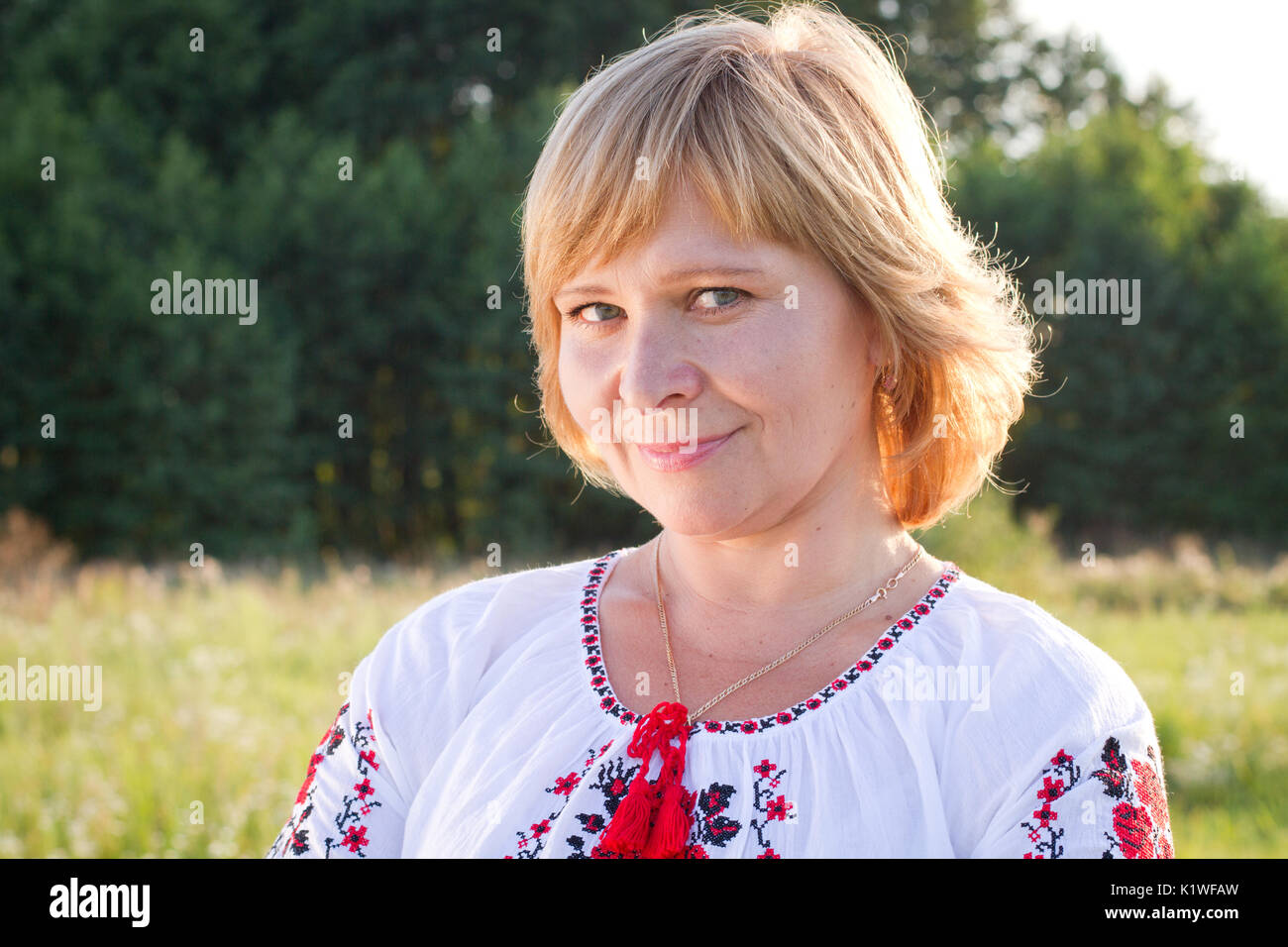 Happy woman smiling in the nature background Stock Photo - Alamy