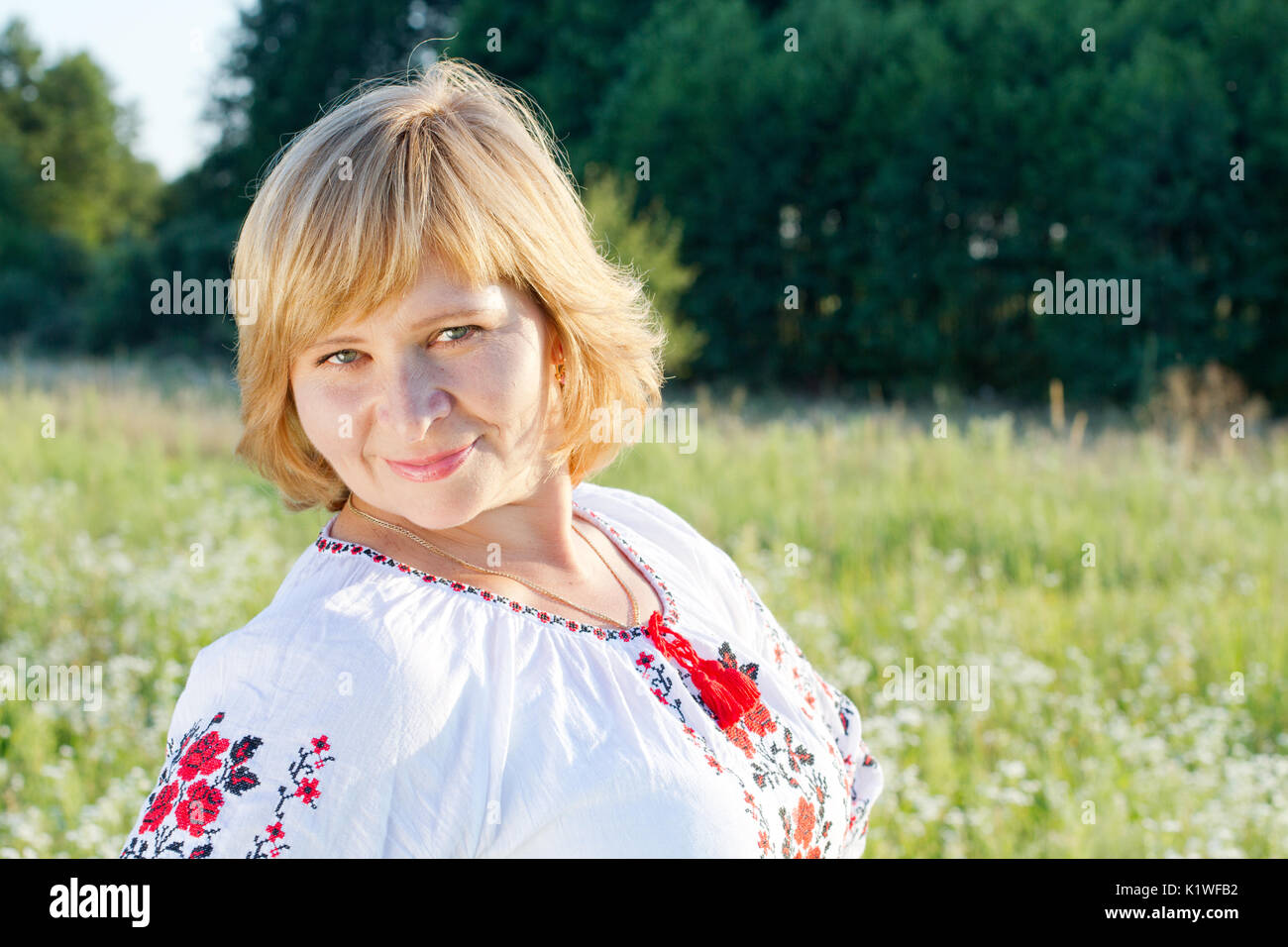 Happy woman smiling in the nature background Stock Photo - Alamy