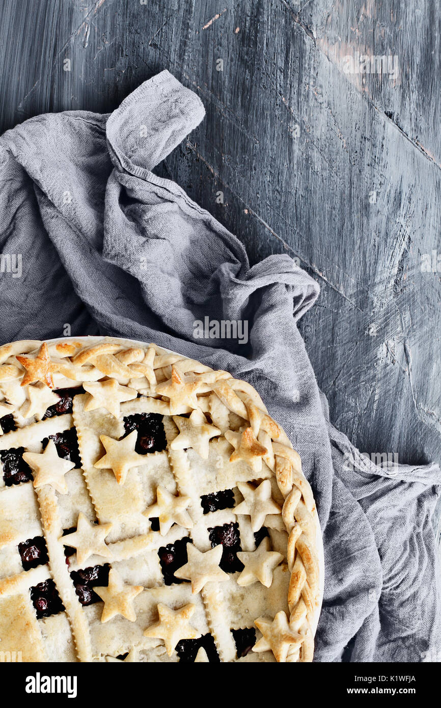 Top view of a blueberry pie with lattice and stars crust over a rustic ...