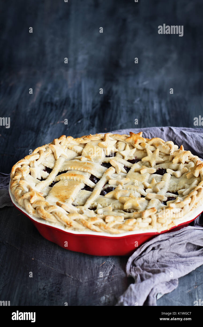 Sweet blueberry pie with lattice and stars crust in a red pie plate ...