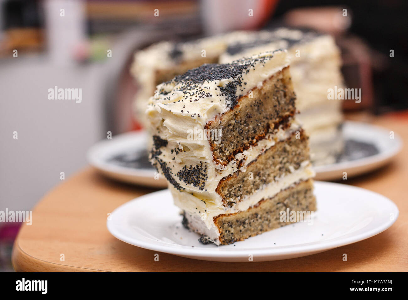 sponge cake with poppy seeds layered with cream with a cut out piece on ...