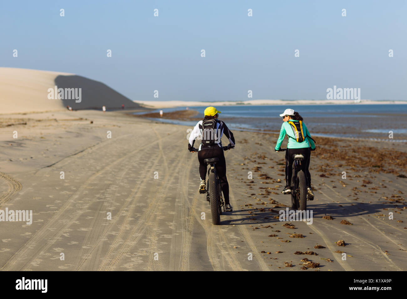 couple riding on a bike with fat sand tires in a beach in Jericoacoara ...