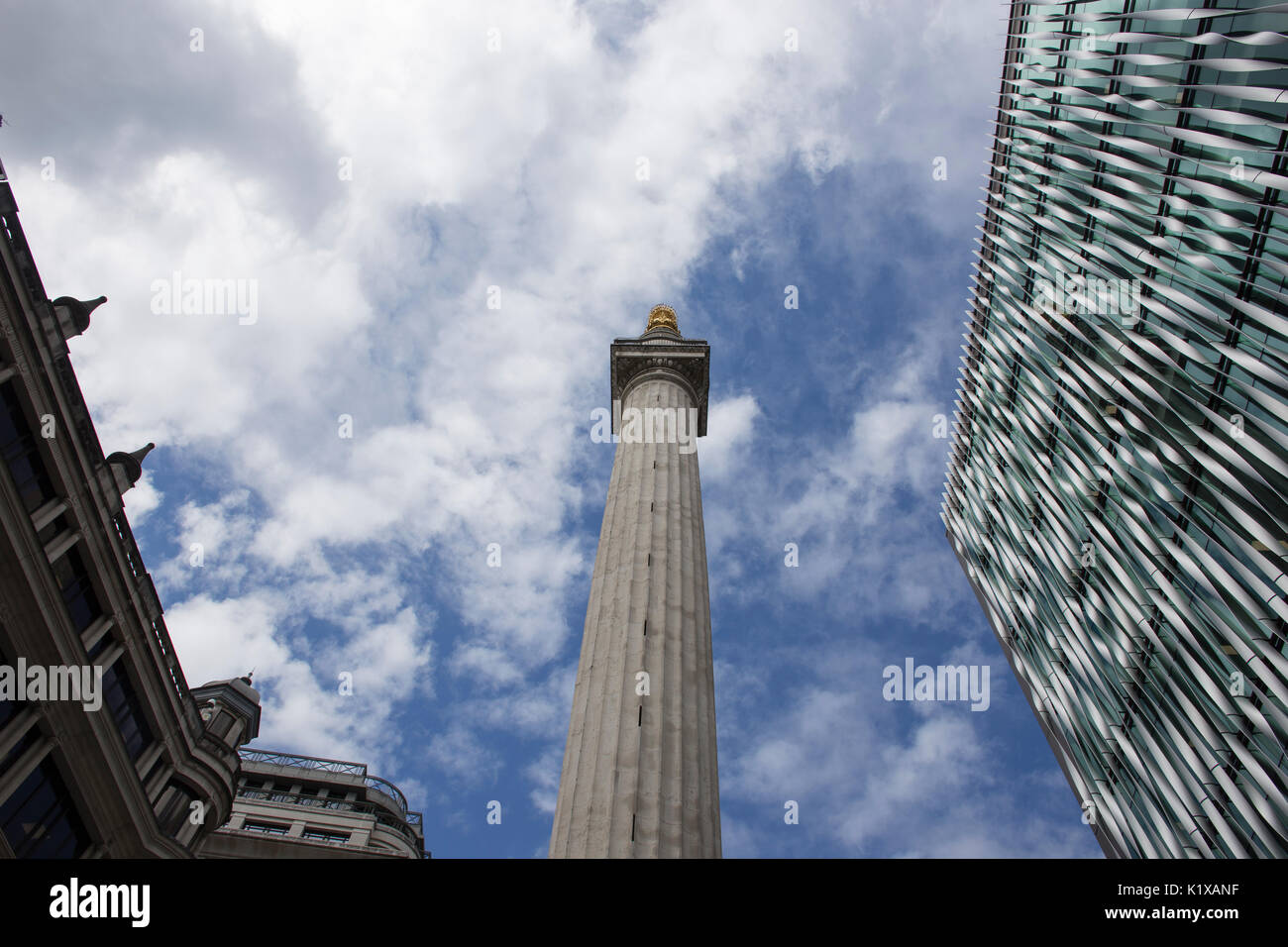 Looking up at the Monument to the Great Fire of London, with clouds and ...