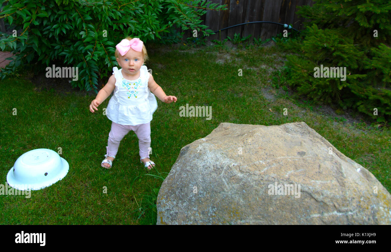 The first steps of a small child in nature on the green grass. August ...