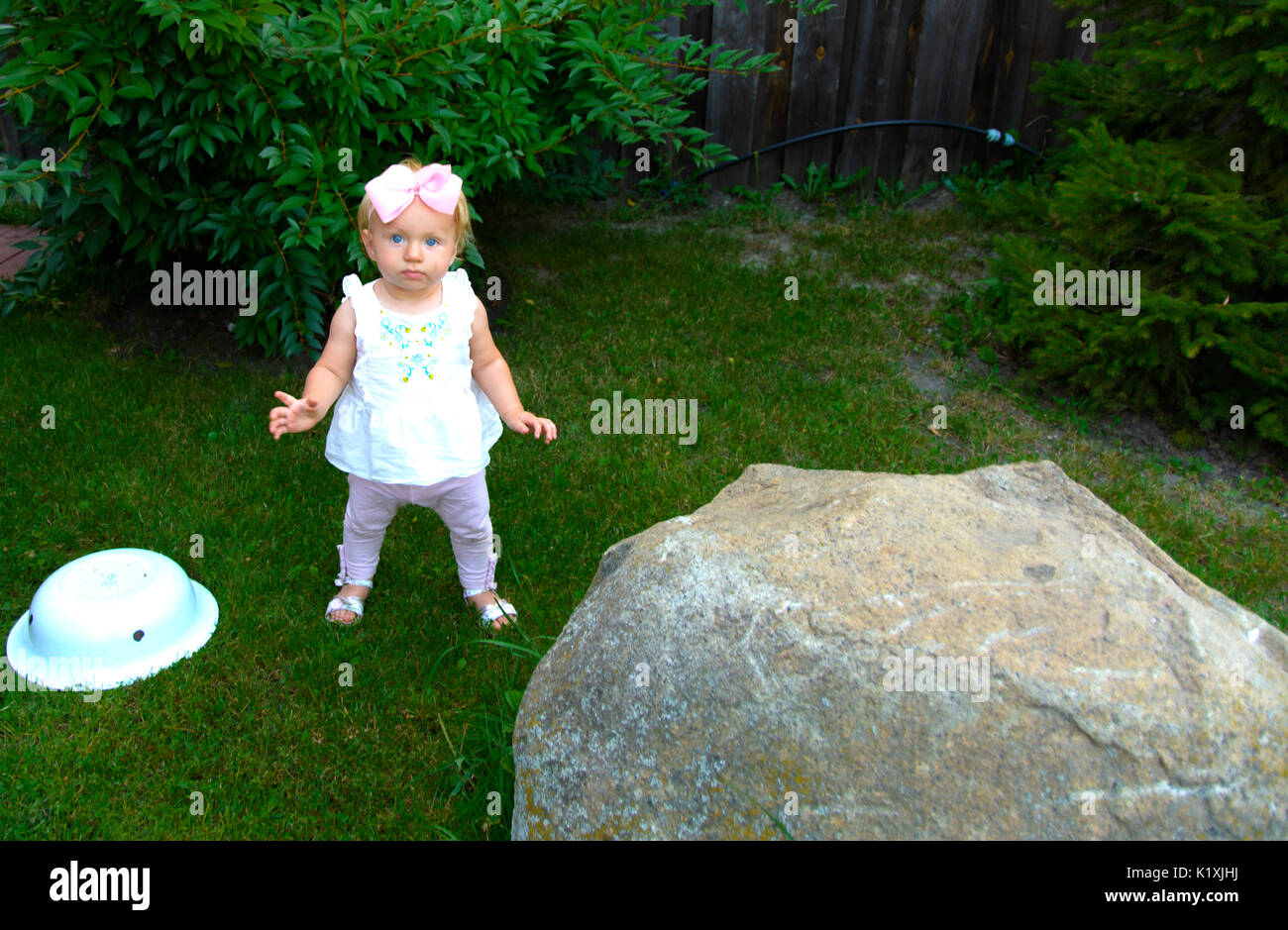 The first steps of a small child in nature on the green grass. August ...