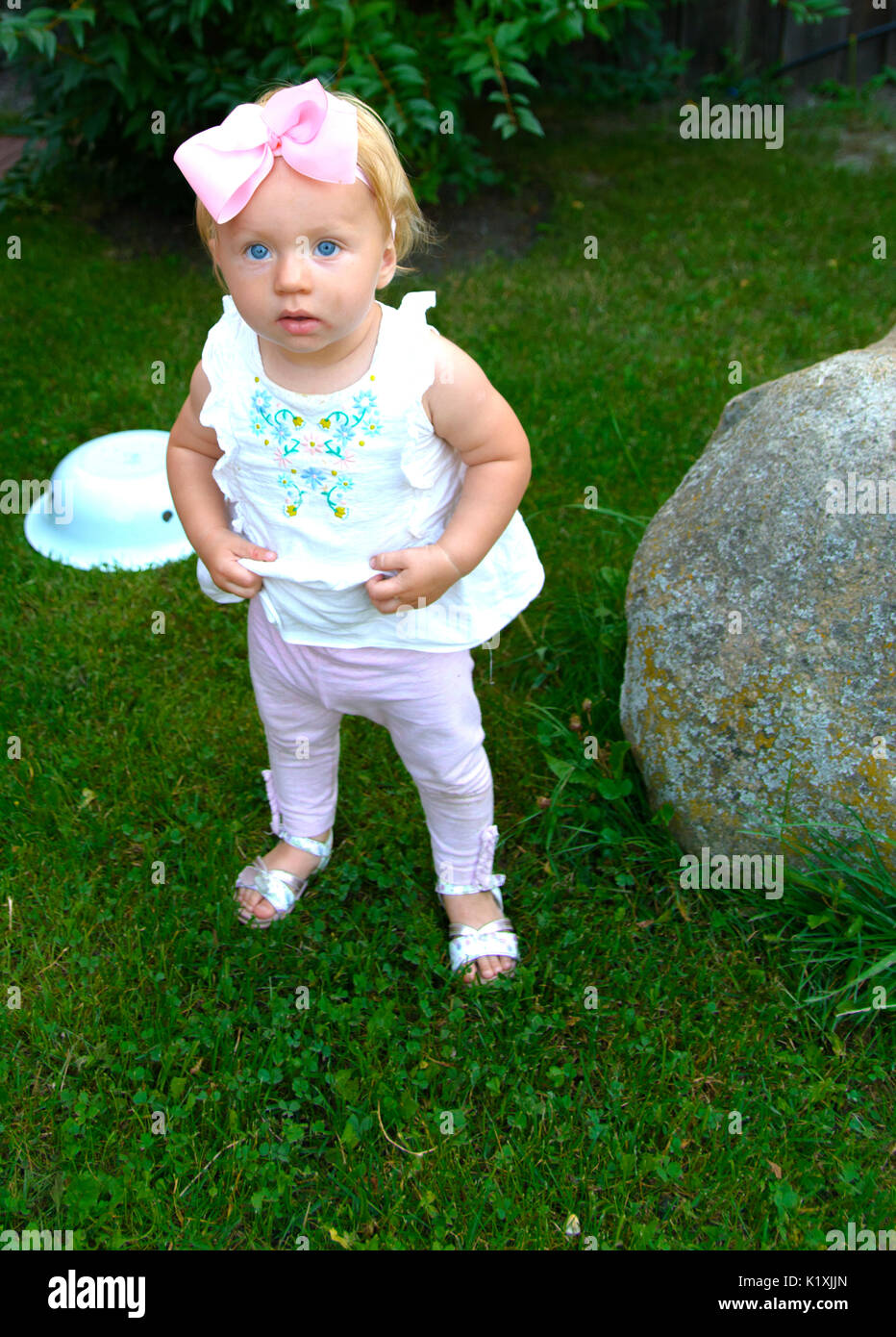 The first steps of a small child in nature on the green grass. August ...