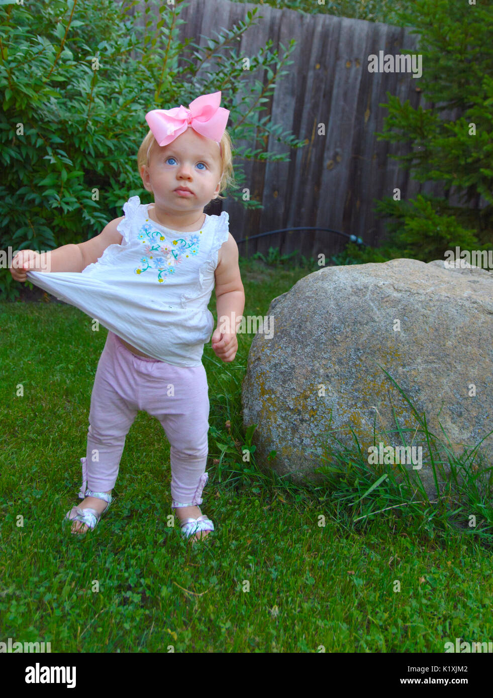 The first steps of a small child in nature on the green grass. August ...