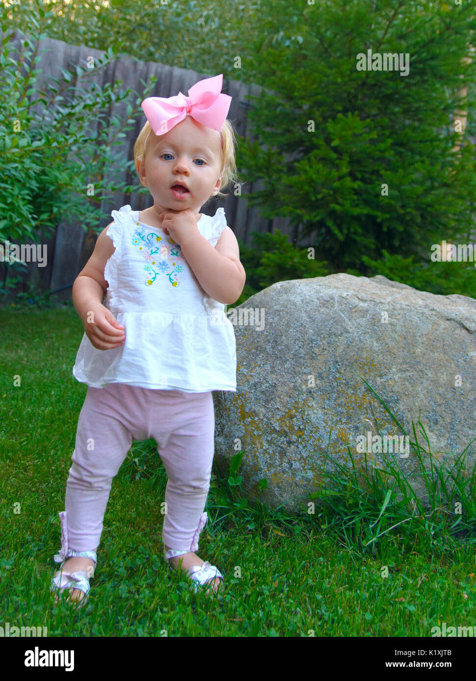 The first steps of a small child in nature on the green grass. August ...