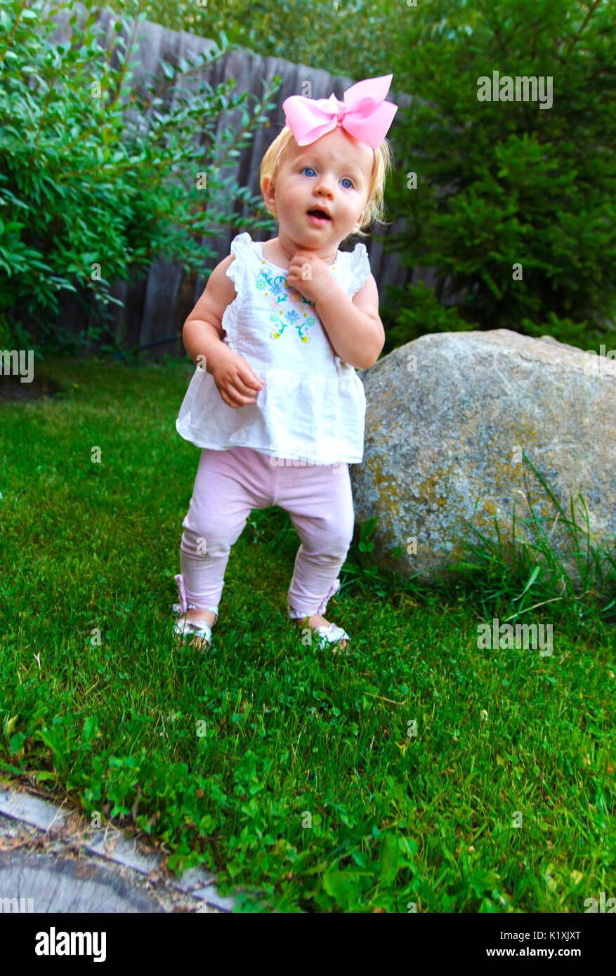 The first steps of a small child in nature on the green grass. August ...