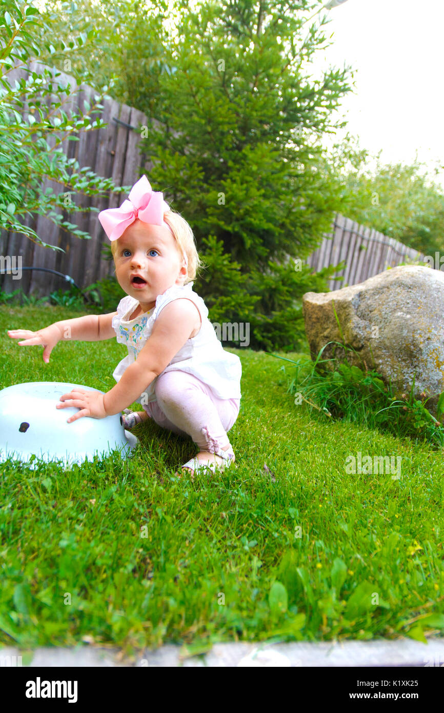 The first steps of a small child in nature on the green grass. August ...