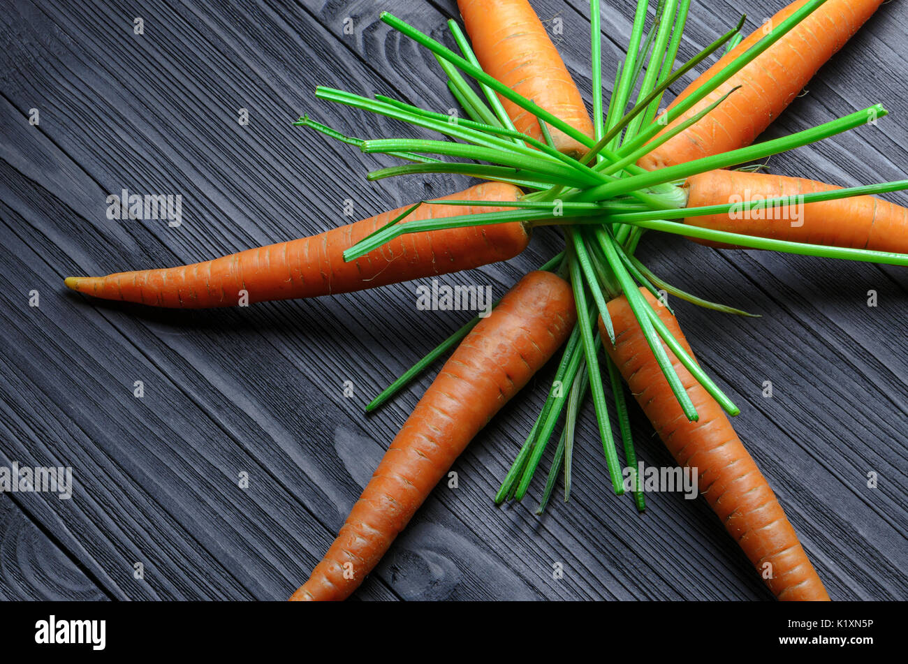Fresh carrots carefully laid out in a geometric pattern on a black ...