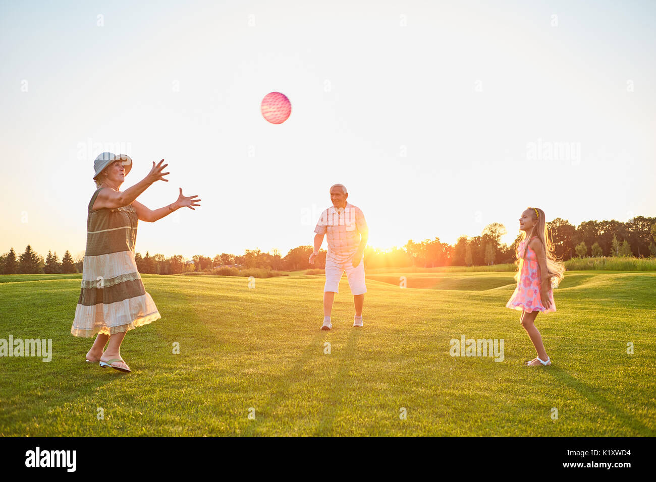 Girl and grandparents playing ball. People having fun outdoors, summer ...