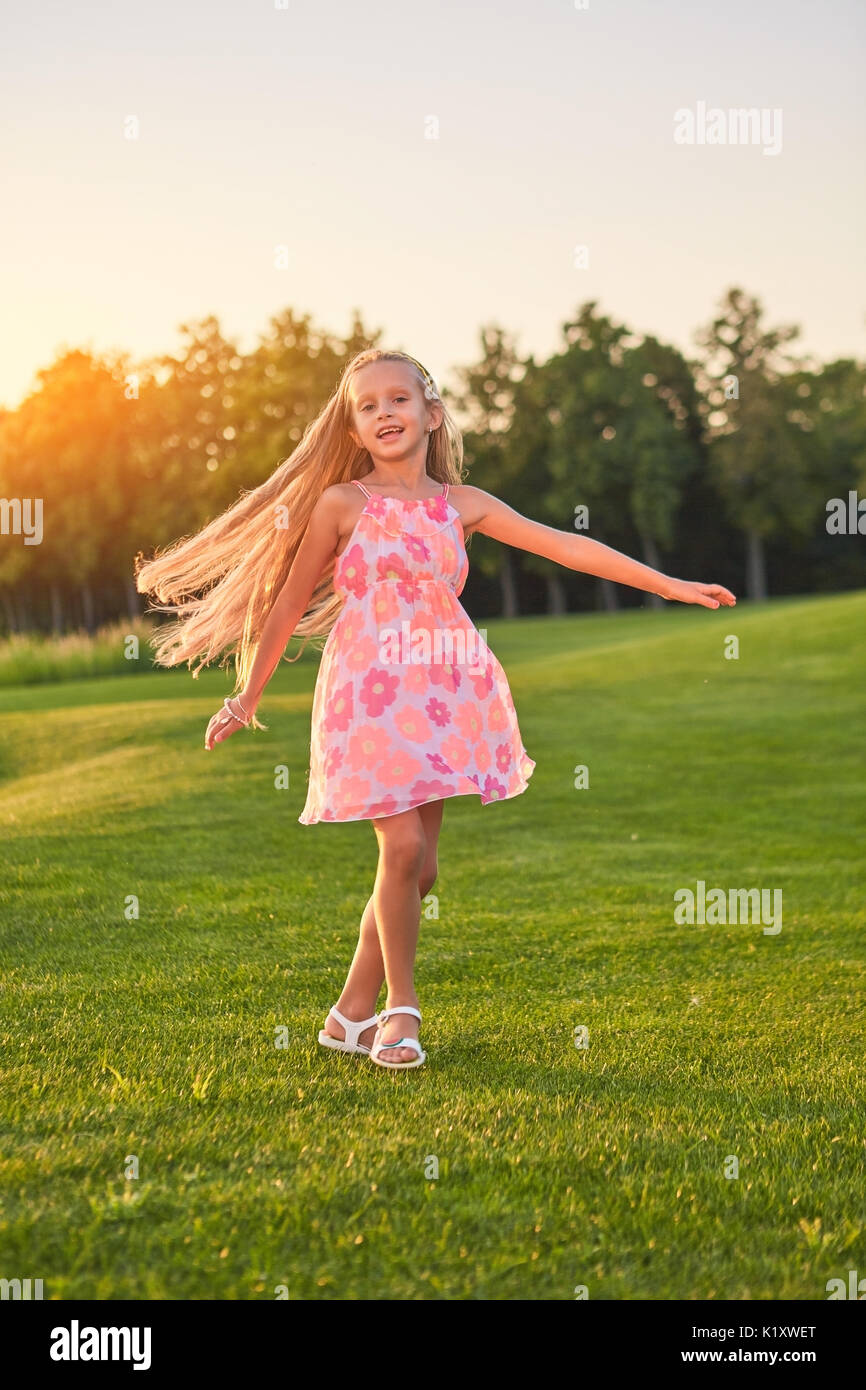 Cute little girl dancing outdoors. Child and green grass Stock Photo ...