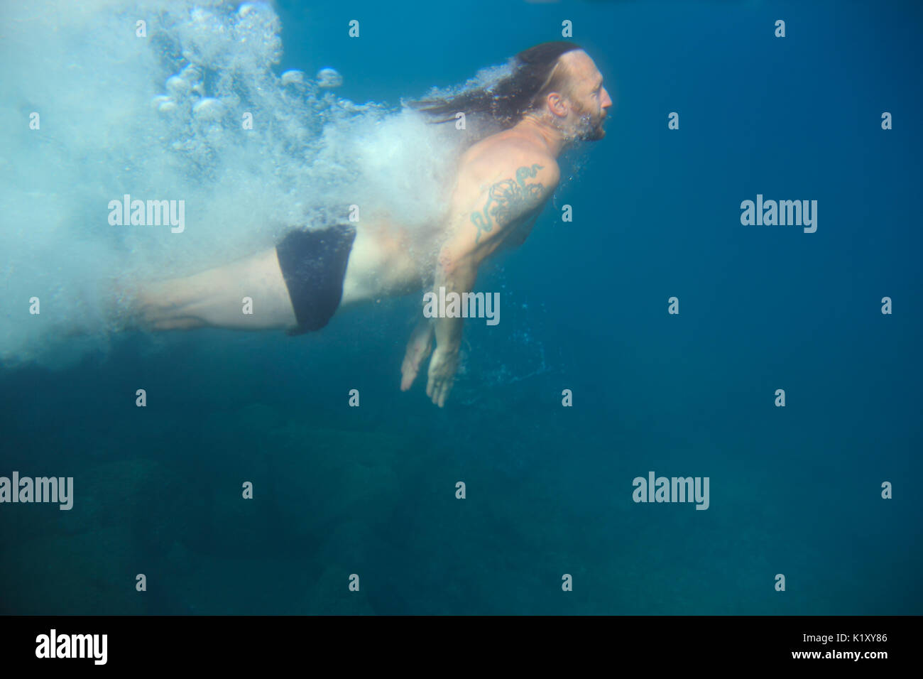 Man swimming underwater in blue transparent sea water Stock Photo - Alamy