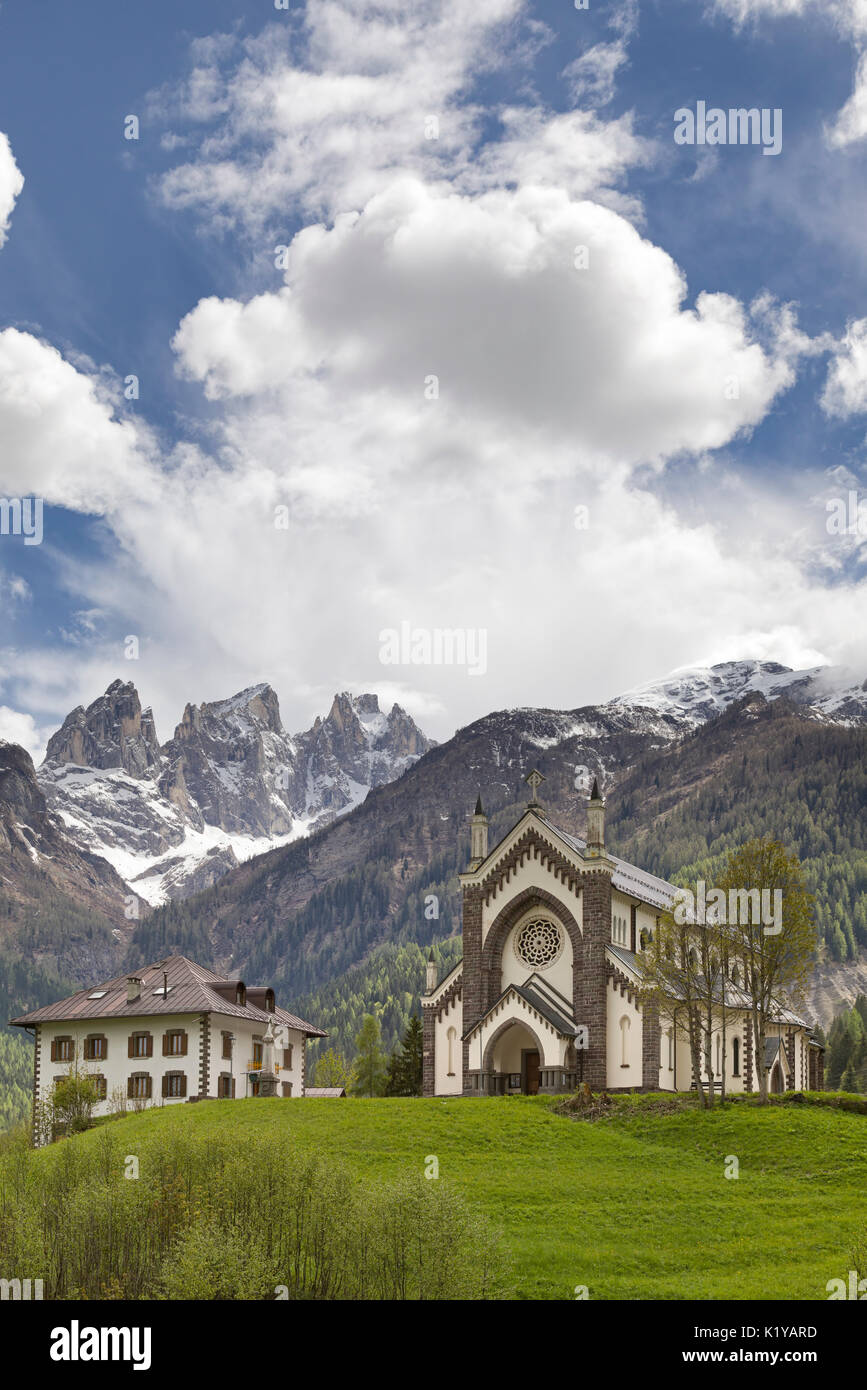 Europe, Italy, Veneto, Falcade. The parish church and the peaks of the ...