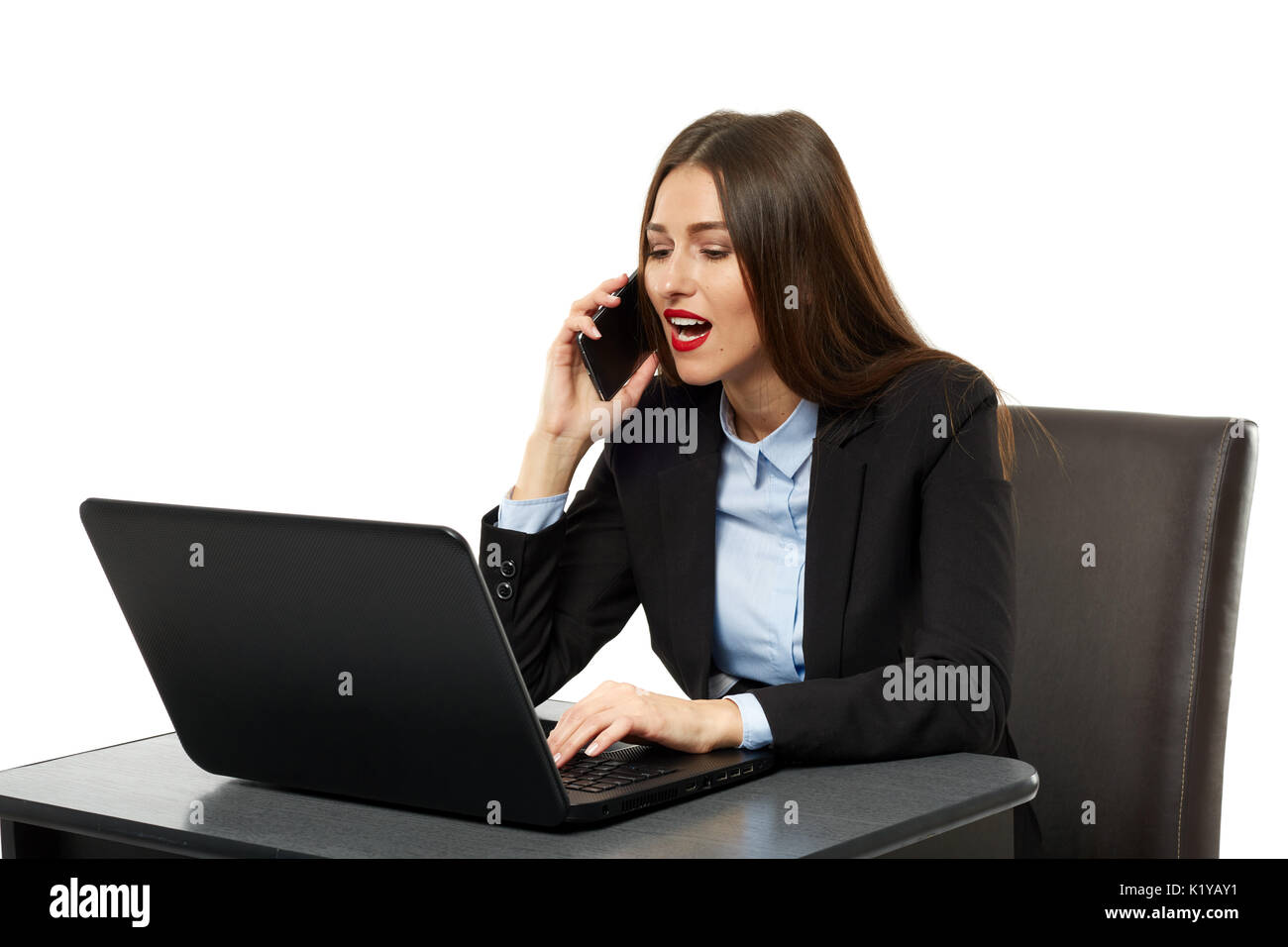 Young businesswoman speaking on her phone while looking at laptop Stock ...
