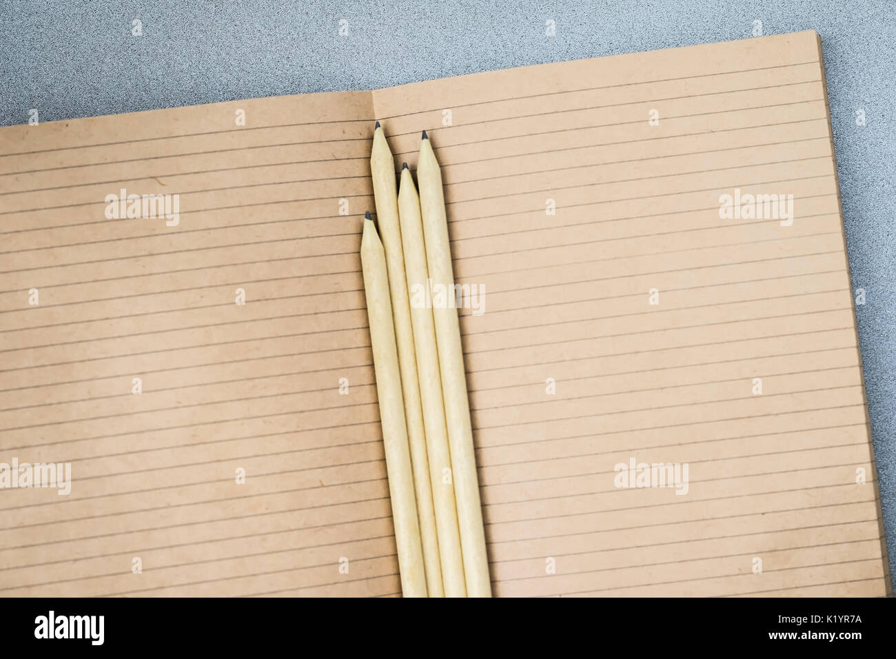 Pencils and open notebook paper from craft paper, top view, texture ...