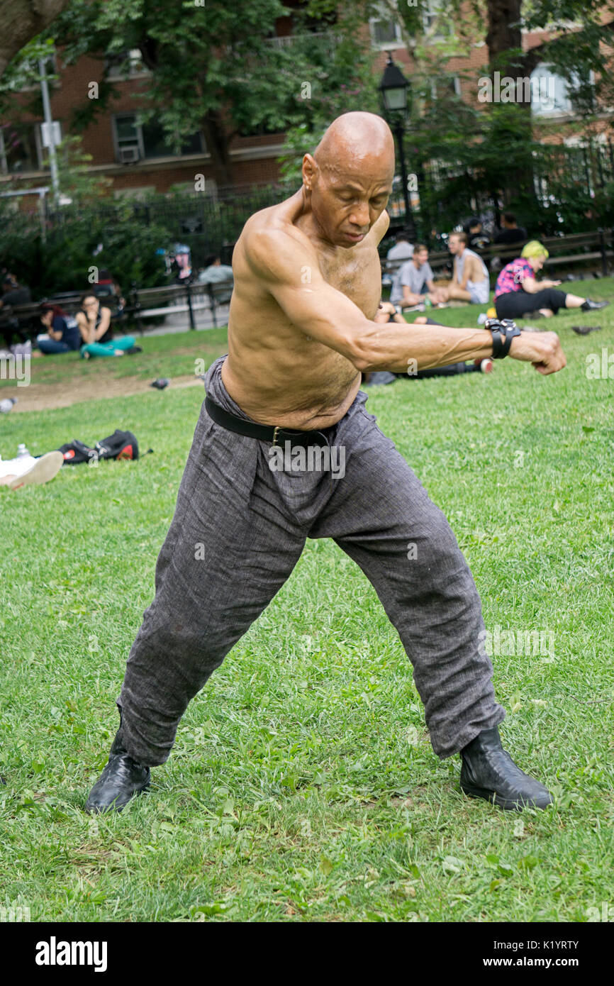 A fit shirtless 67 year old man practices kung fu moves outdoors in ...