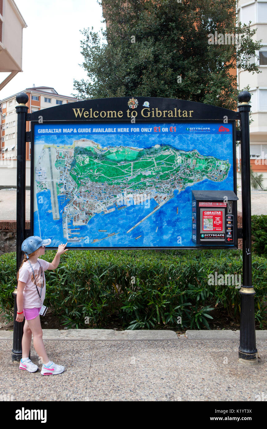 7 year old British child pointing at welcome to Gibraltar sign, map and ...