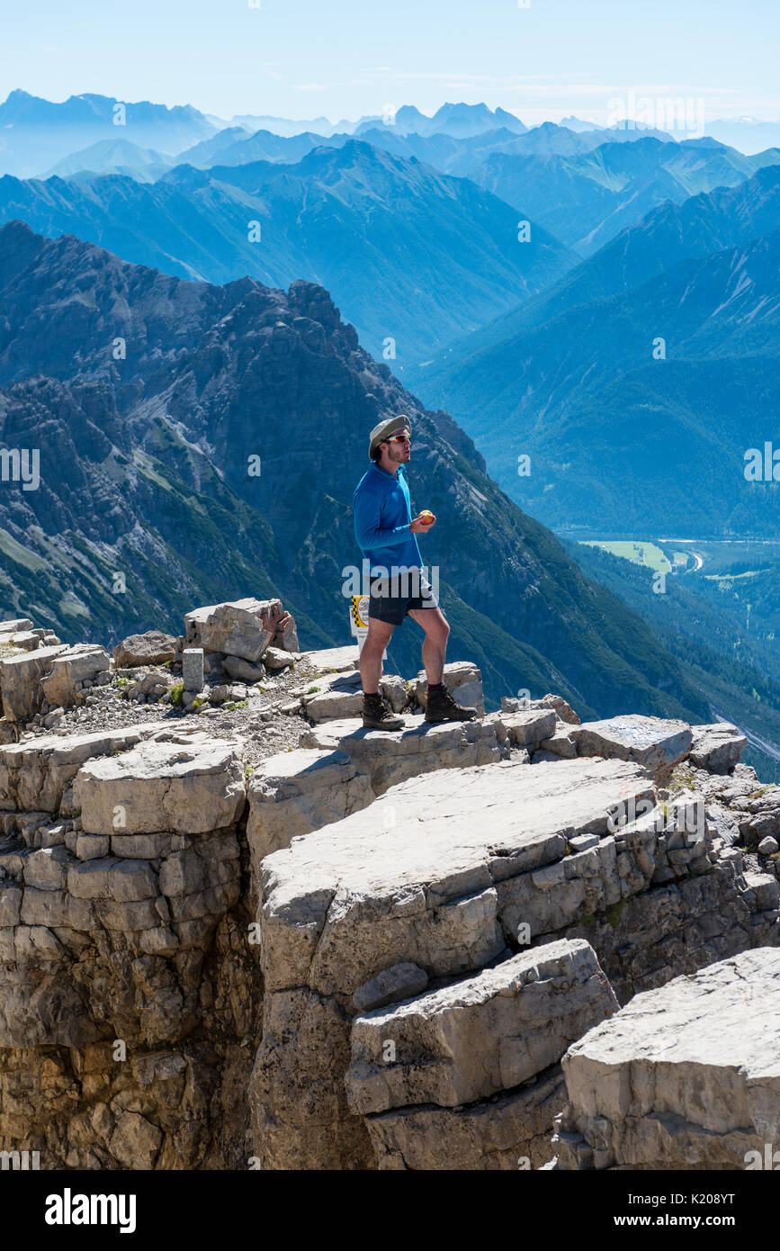 Hiker looking at landscape, mountains and Alps, summit of Hochvogel ...