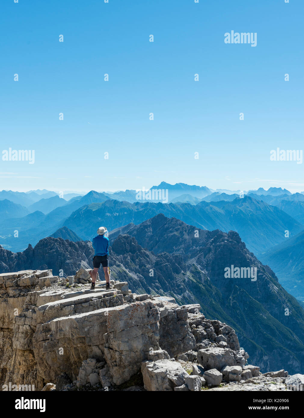 Hiker looking at landscape, mountains and Alps, summit of Hochvogel ...