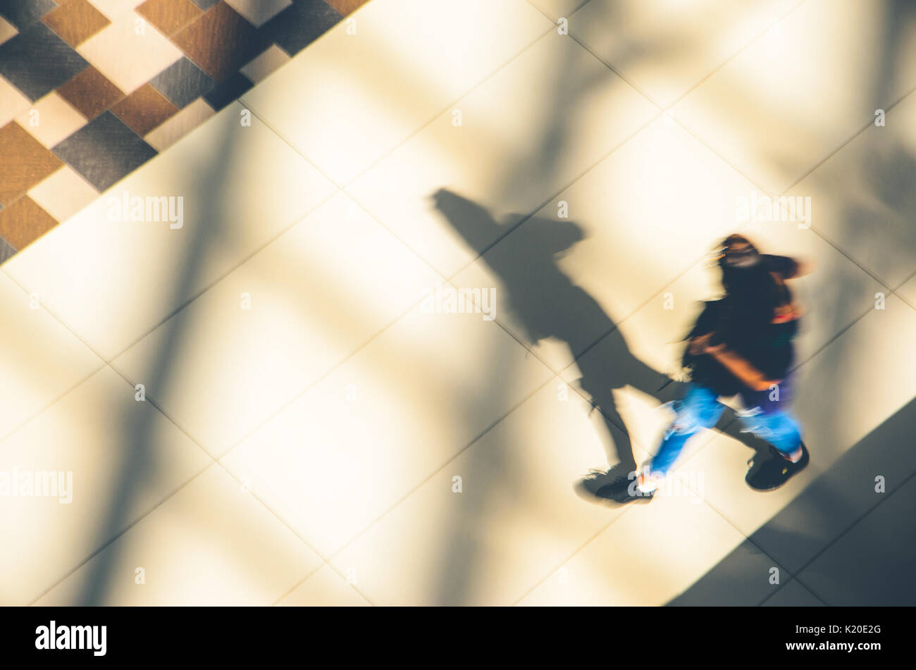 Silhouette of a walking woman with long shadow from above. Abstract ...