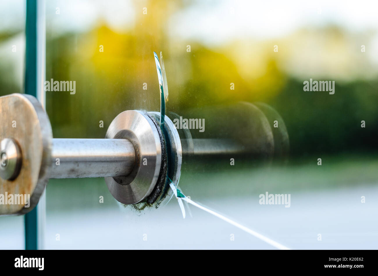 Closeup Modern glass fence with broken glass panel at the junction of ...