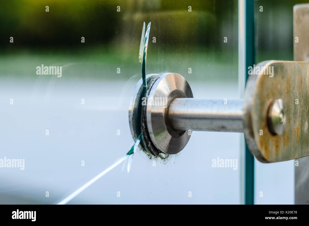 Closeup Modern glass fence with broken glass panel at the junction of ...