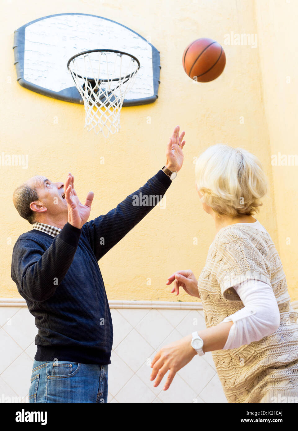Adult people playing with ball in yard and laughing Stock Photo - Alamy