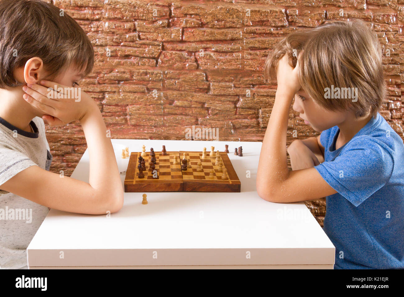 Two children playing chess at the table Stock Photo - Alamy