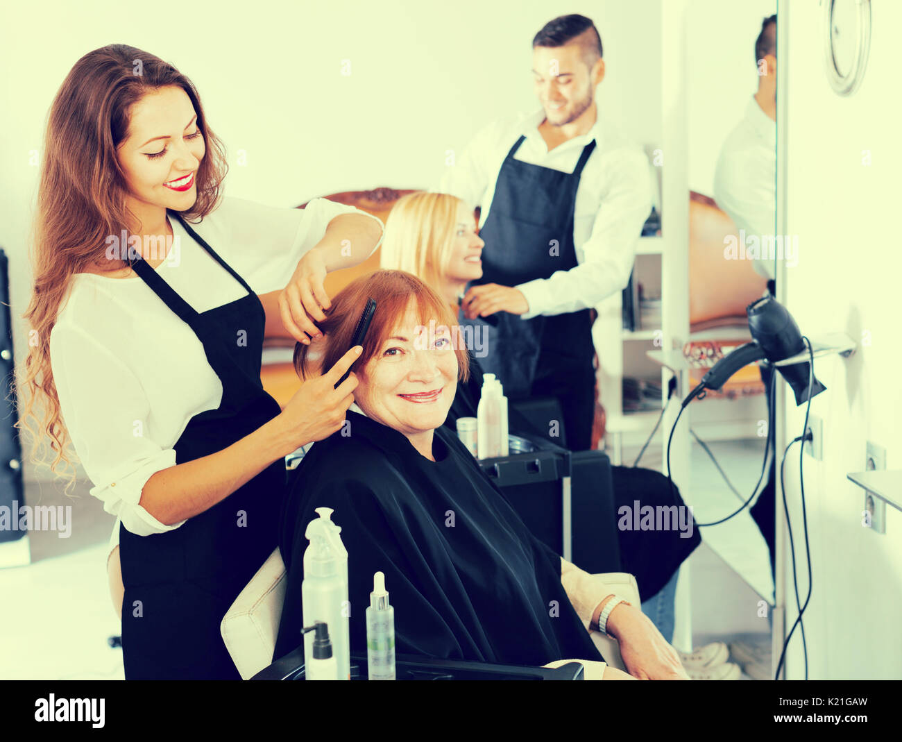 russian barber makes the cut for mature woman Stock Photo - Alamy