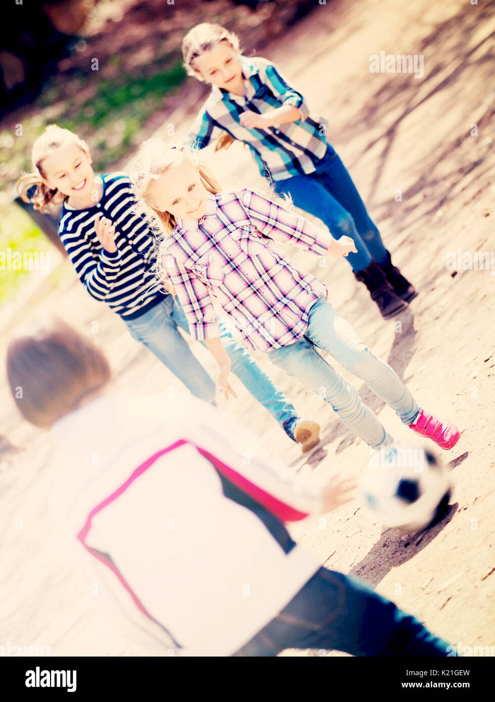 Group of happy positive children running after ball in urban location ...