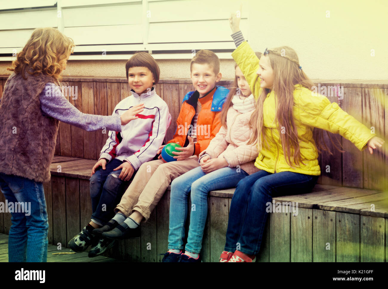 Positive kids trying to guess what friend shows in charades outdoor ...