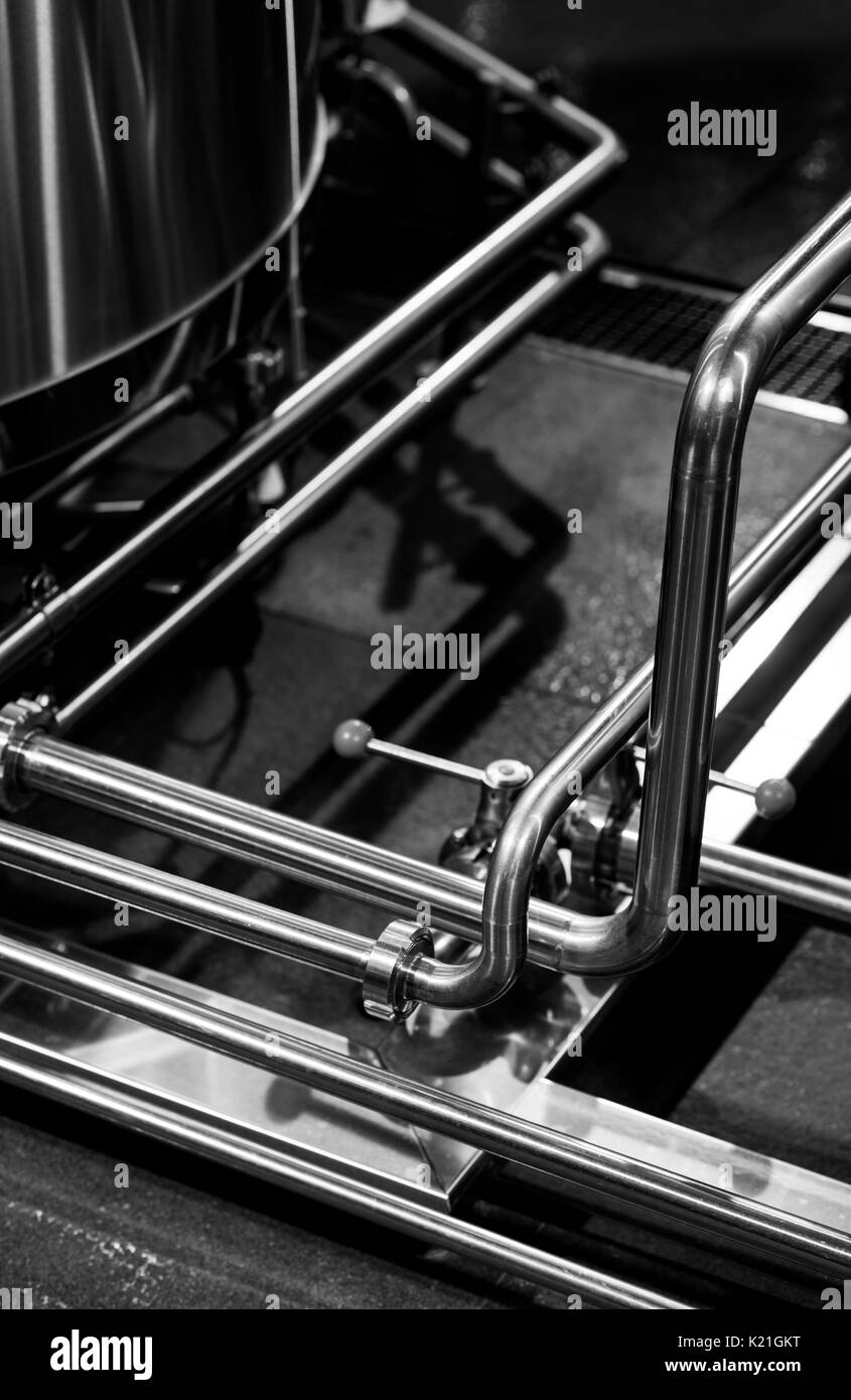 Black and white photo of modern brewery equipment with pipes for giving ...