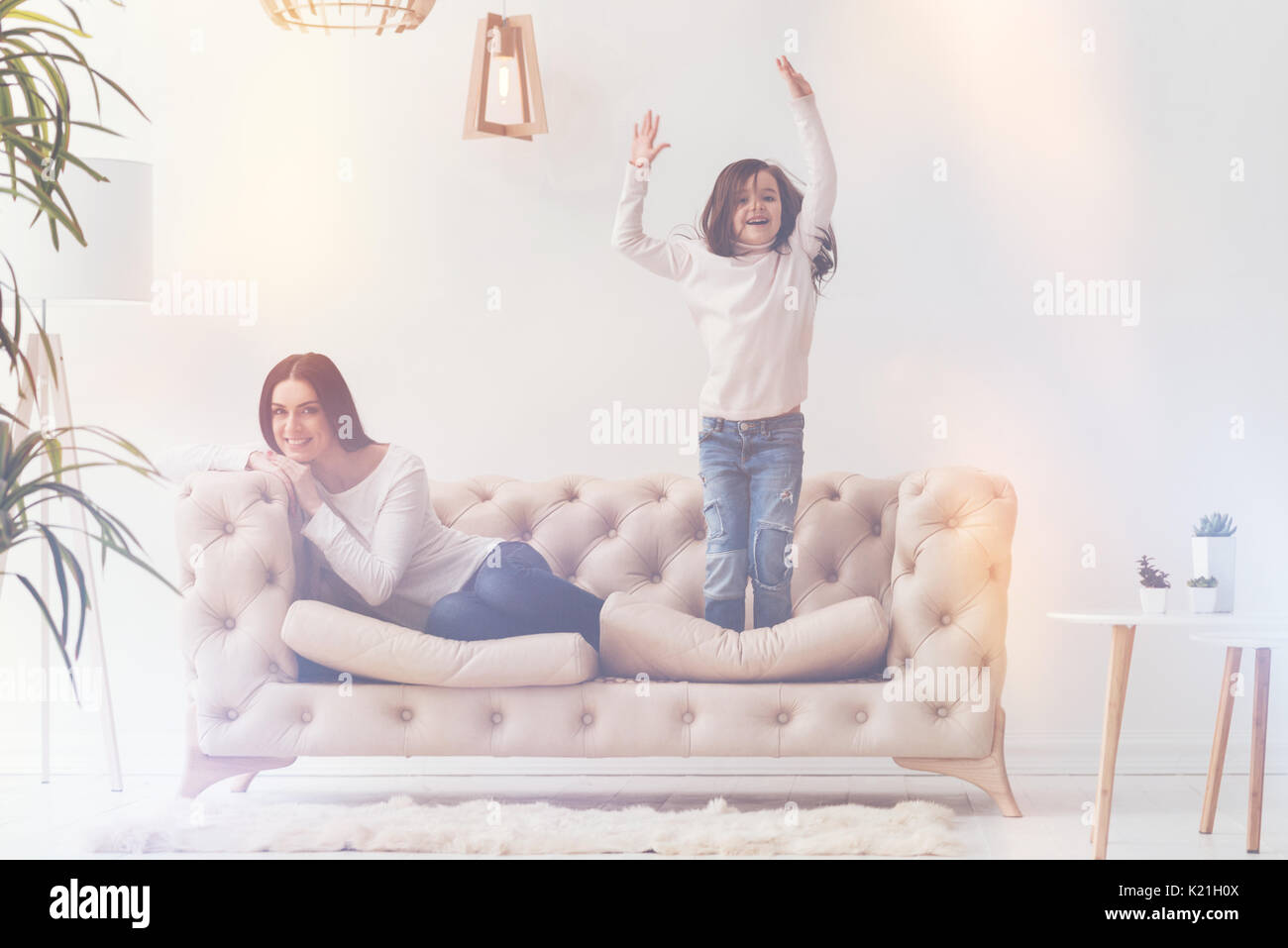 Nice active vibrant girl cheering up her mom Stock Photo - Alamy