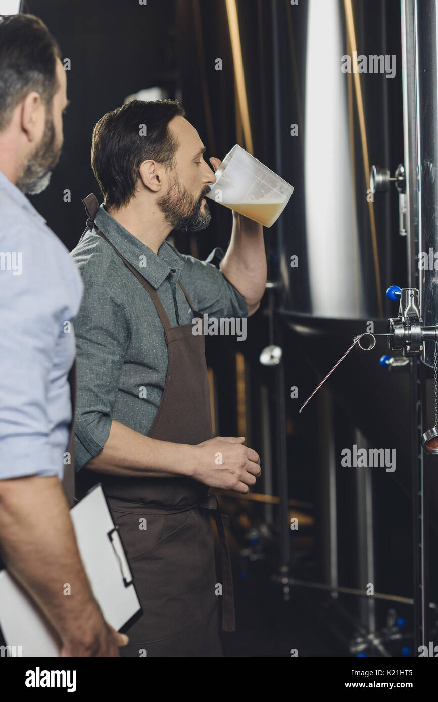 Male brewer drink beer from plastic pitcher at the brewety Stock Photo ...