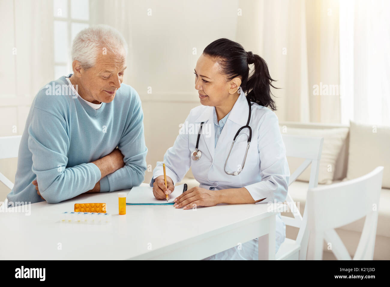Joyful positive doctor taking notes Stock Photo - Alamy