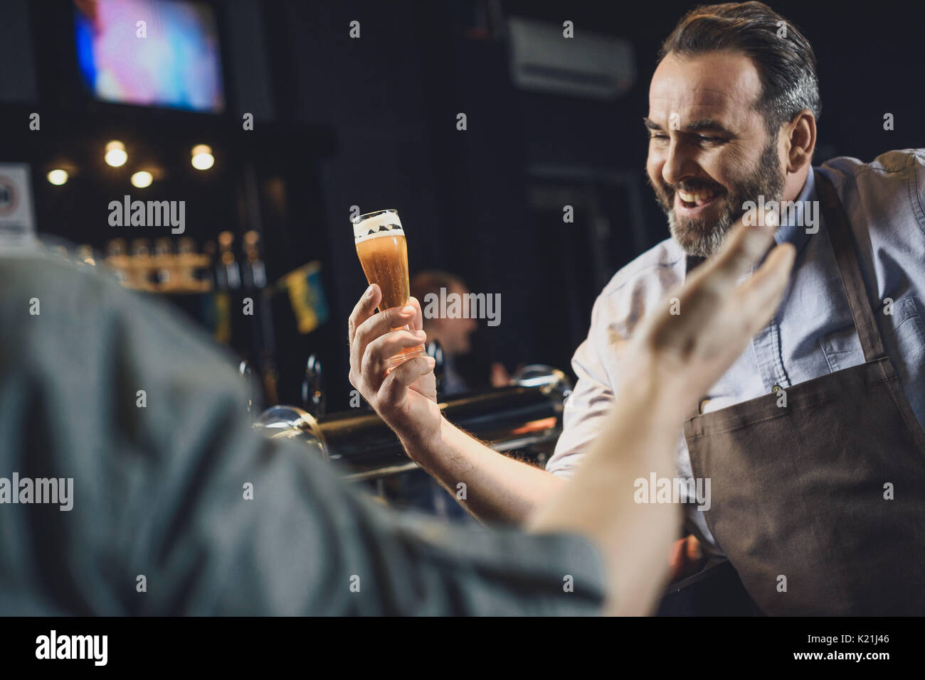 Happy brewery worker holding small glass of beer Stock Photo - Alamy