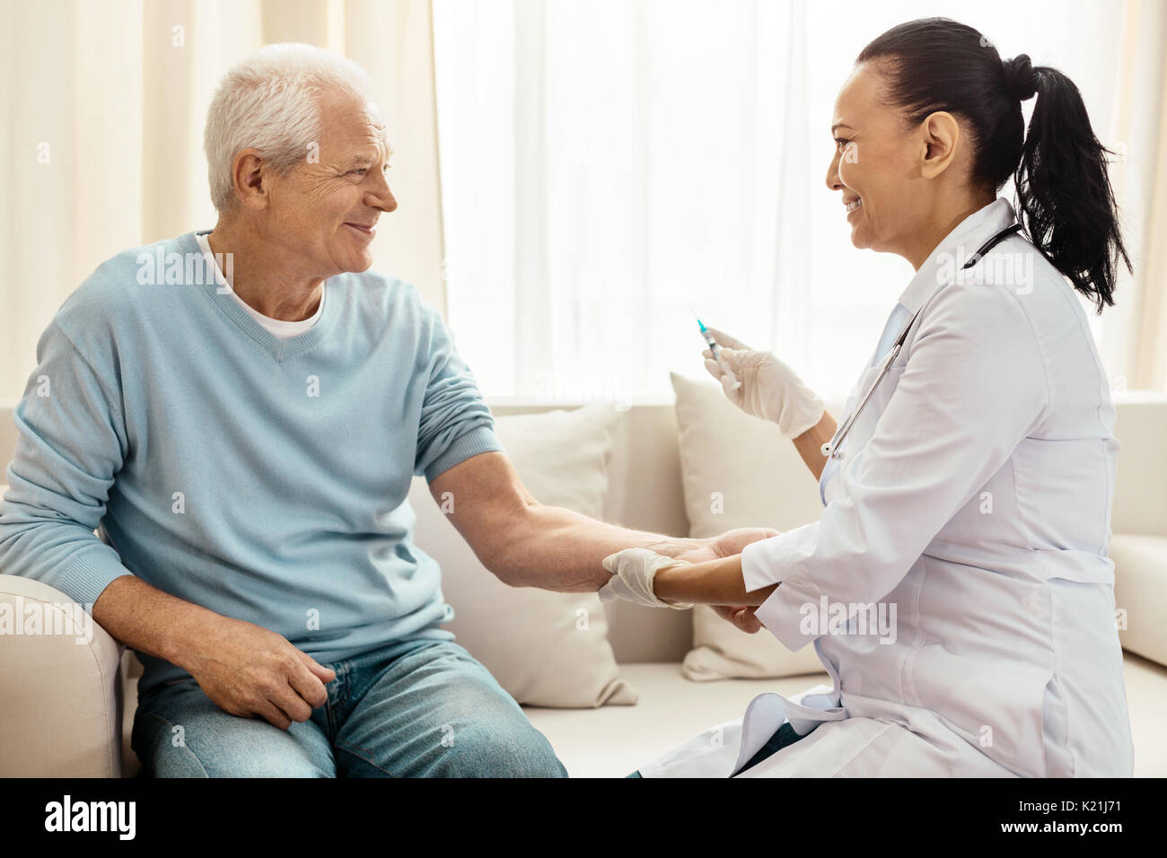 Cheerful positive nurse holding a syringe Stock Photo - Alamy