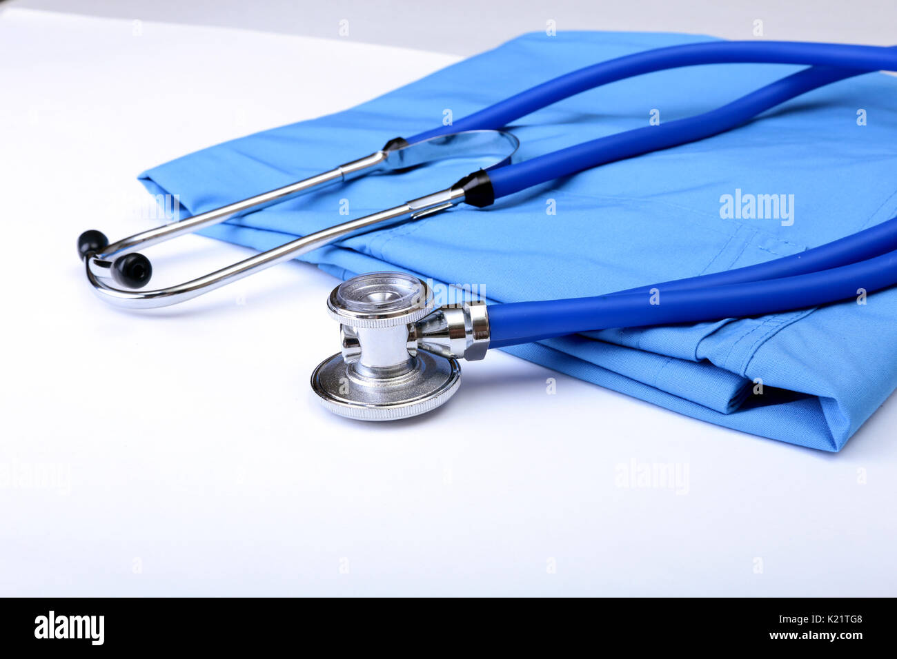 Medical stethoscope head lying on blue doctor uniform closeup. Medical ...