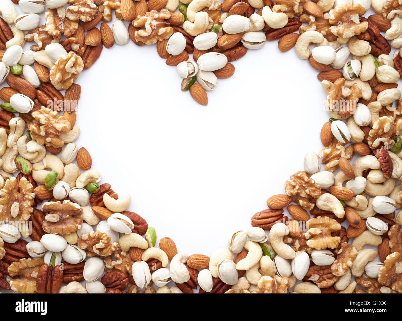 Healthy nuts framing a heart shape over white background Stock Photo ...